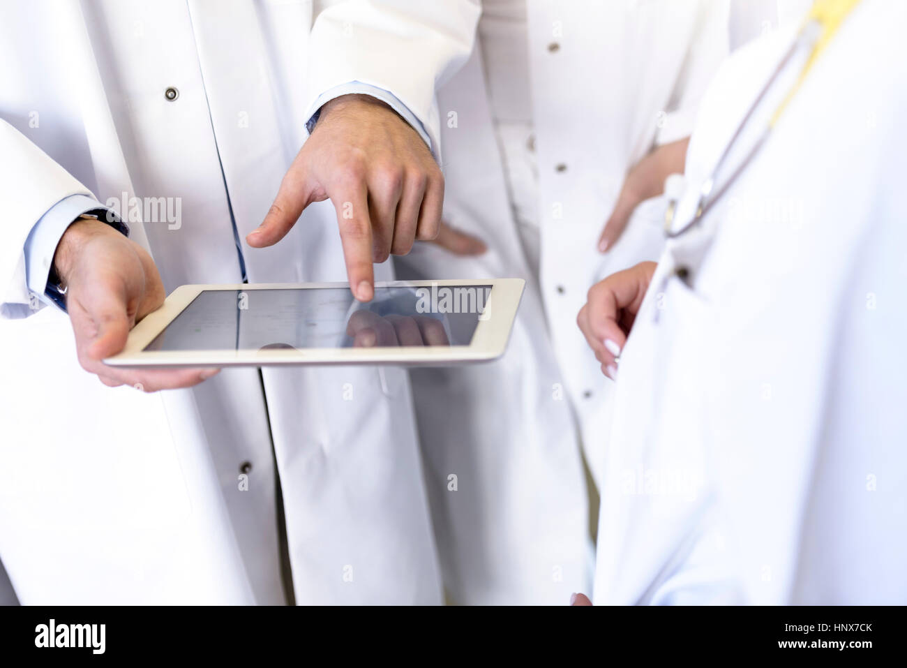 Mid section of male and female doctors using digital pad touchscreen in ...