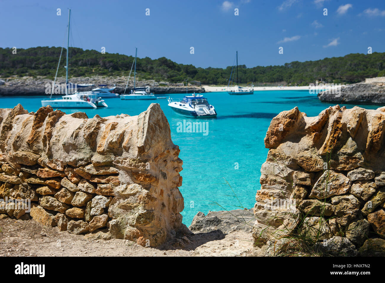 Traditional stone wall and anchored yachts in bay, Majorca, Spain Stock ...