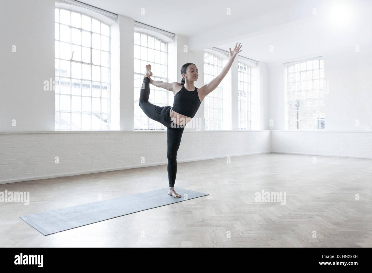 Woman in dance studio leg raised, stretching Stock Photo - Alamy