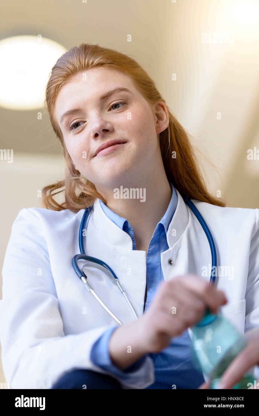 Young female doctor holding bottle of water in hospital Stock Photo - Alamy