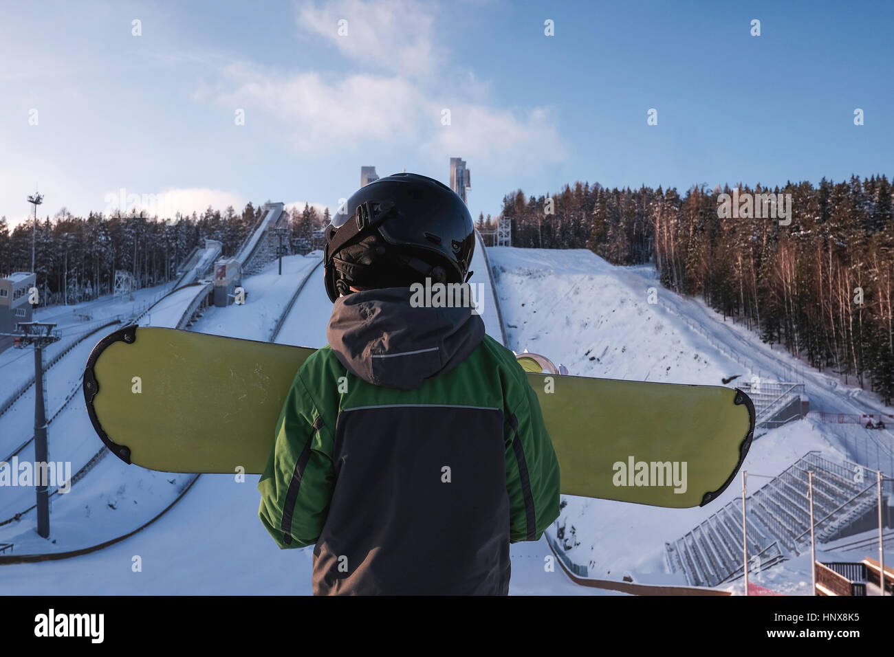 Rear view of boy with snowboard at top of ski slope Stock Photo - Alamy