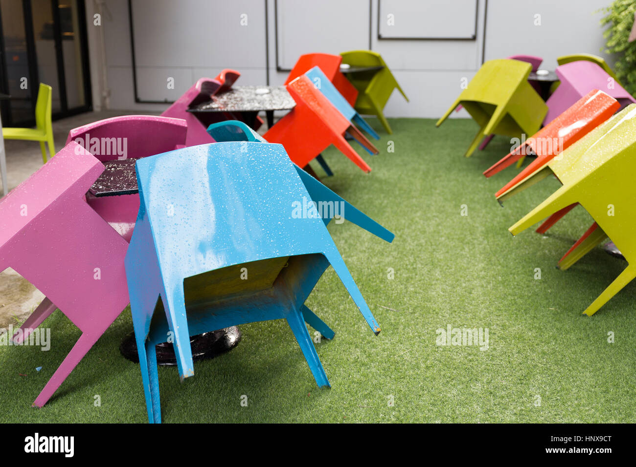 wet colorful plastic chair at terrace after raining Stock Photo - Alamy