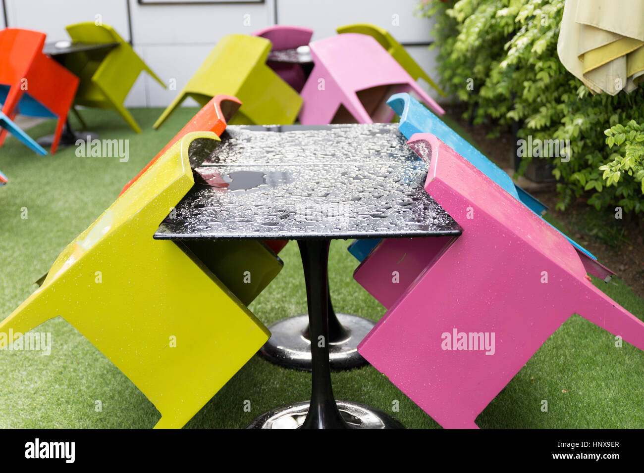 wet colorful plastic chair at terrace after raining Stock Photo - Alamy