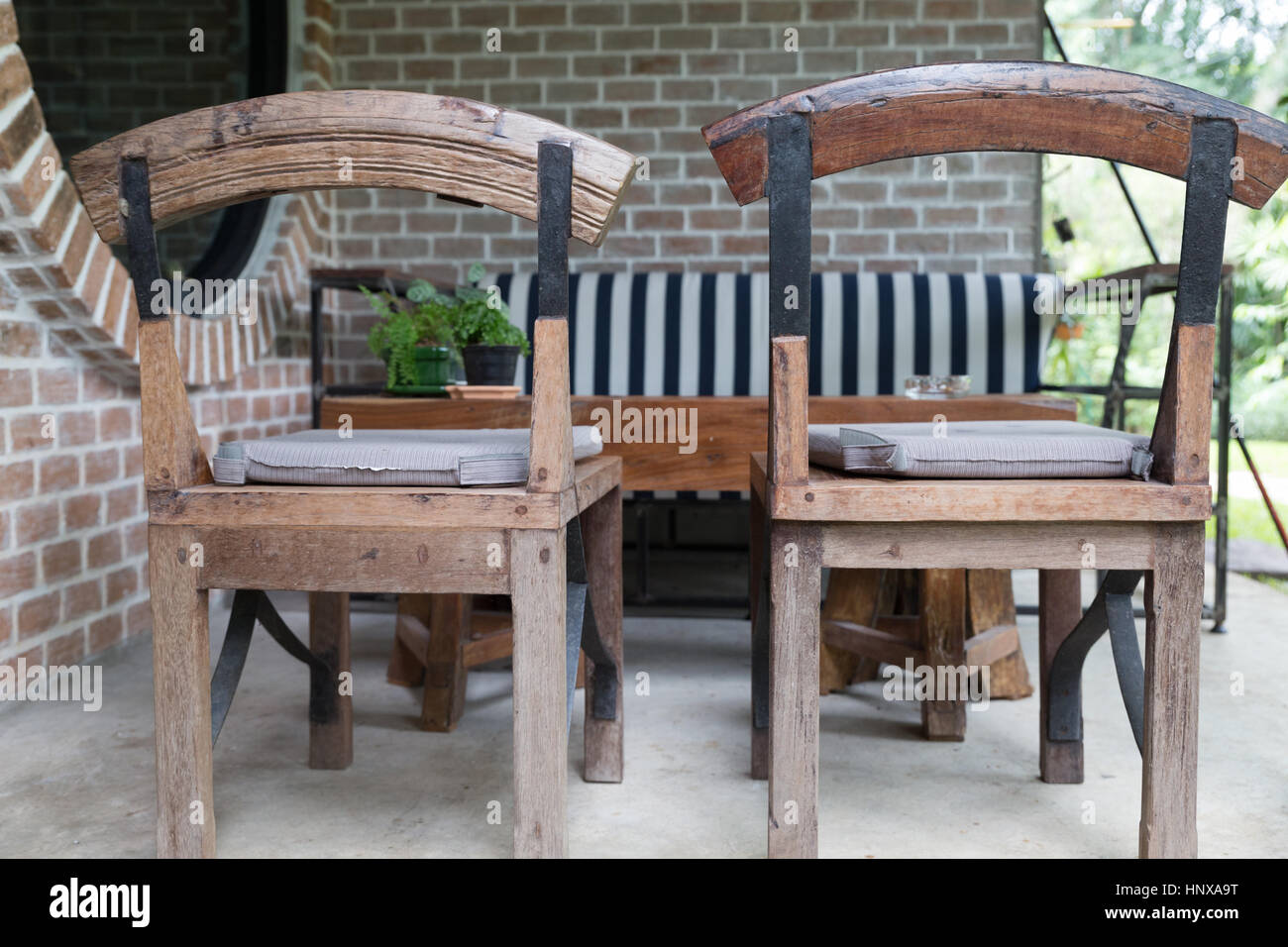 wood chair and table on patio beside garden Stock Photo - Alamy