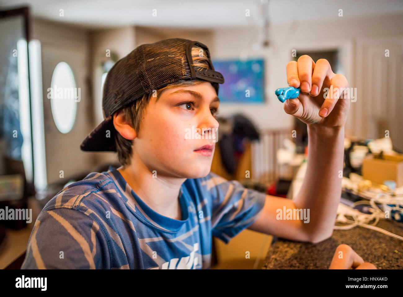 Boy looking at rock Stock Photo - Alamy