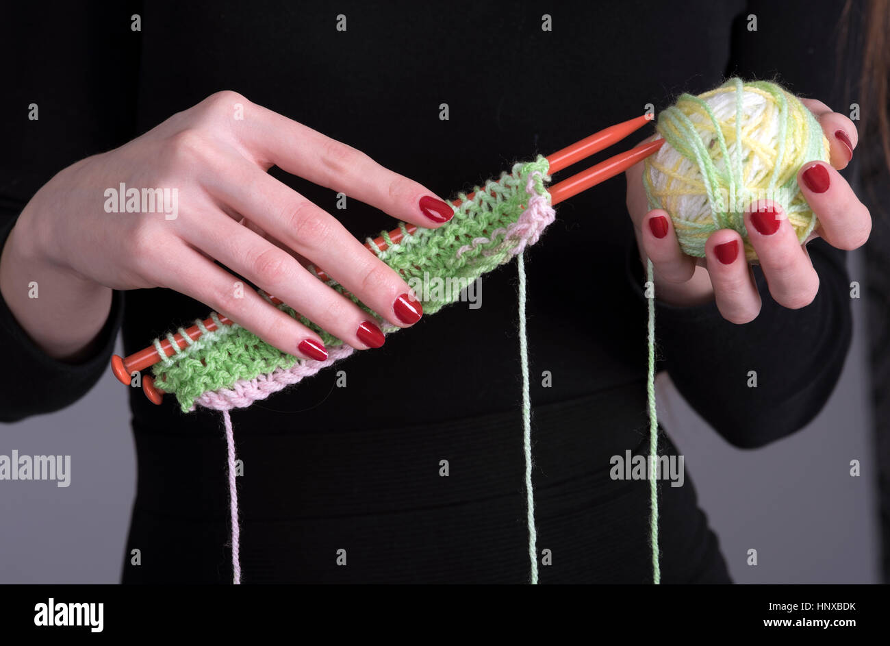 A young person's hands with knitting wool and needles Stock Photo - Alamy