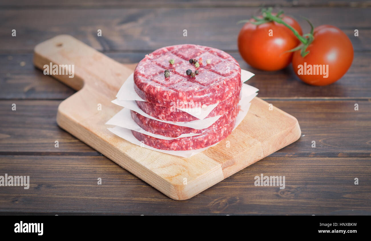 Raw patty and tomatoes Stock Photo - Alamy