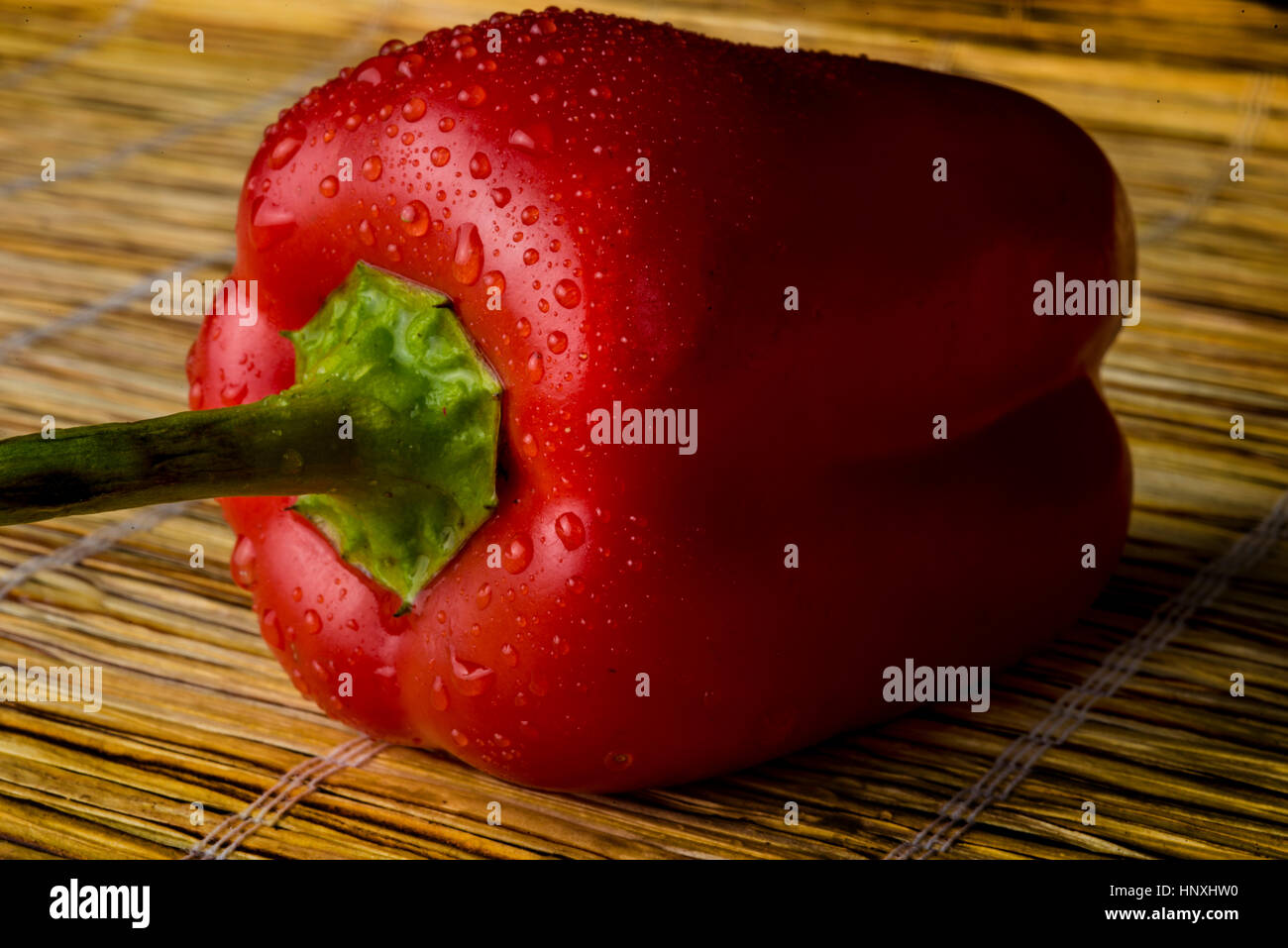 red sweet pepper on straw mat Stock Photo - Alamy