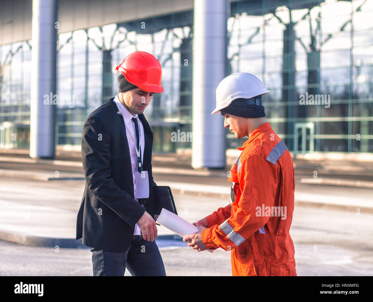 young boss and worker in conversation discussing a construction project ...