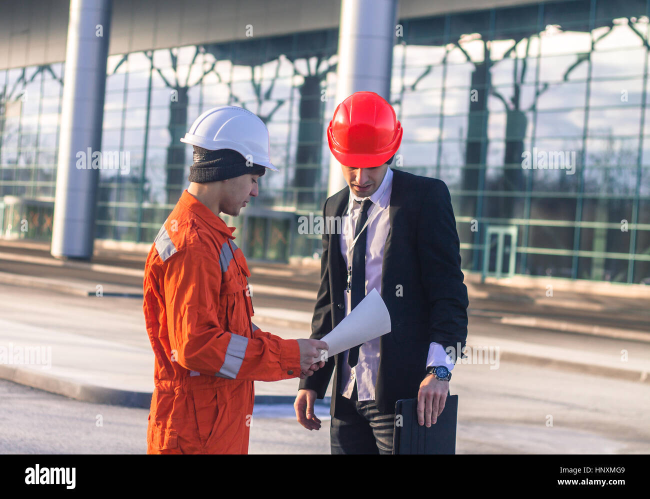 young boss and worker in conversation discussing a construction project ...