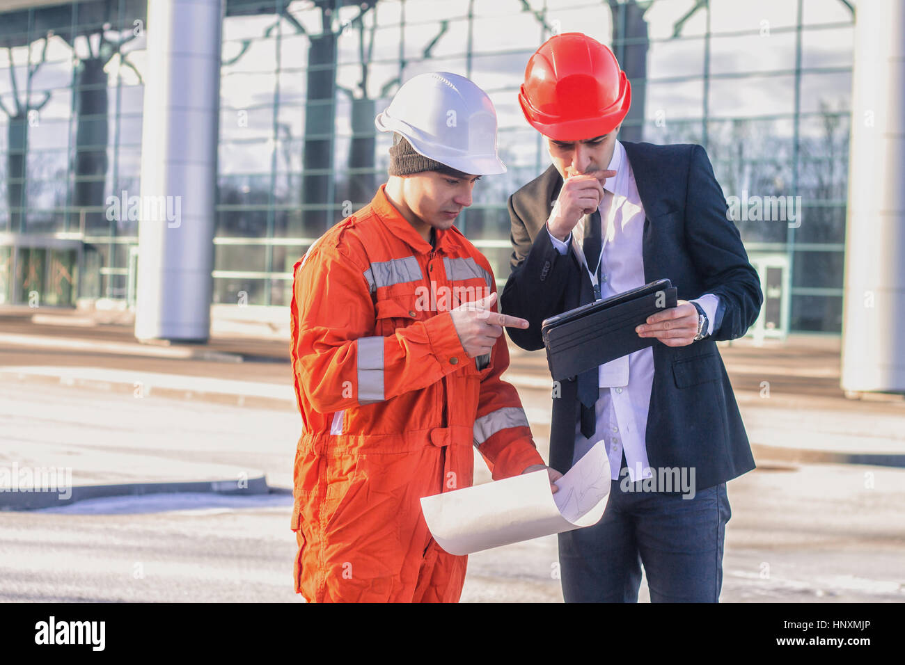young boss and worker in conversation discussing a construction project ...