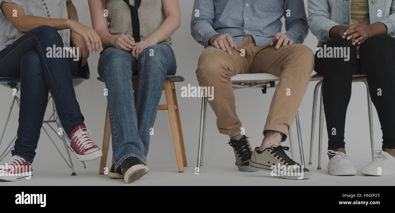 Cropped group of people sitting in a row Stock Photo - Alamy