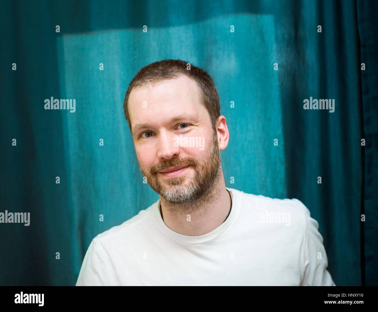 Portrait of an unshaven man with a happy look on his face posing ...