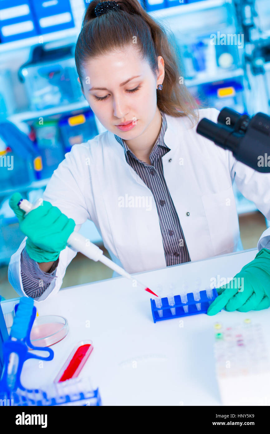 A young chemist holding test tube with liquid during chemical ...