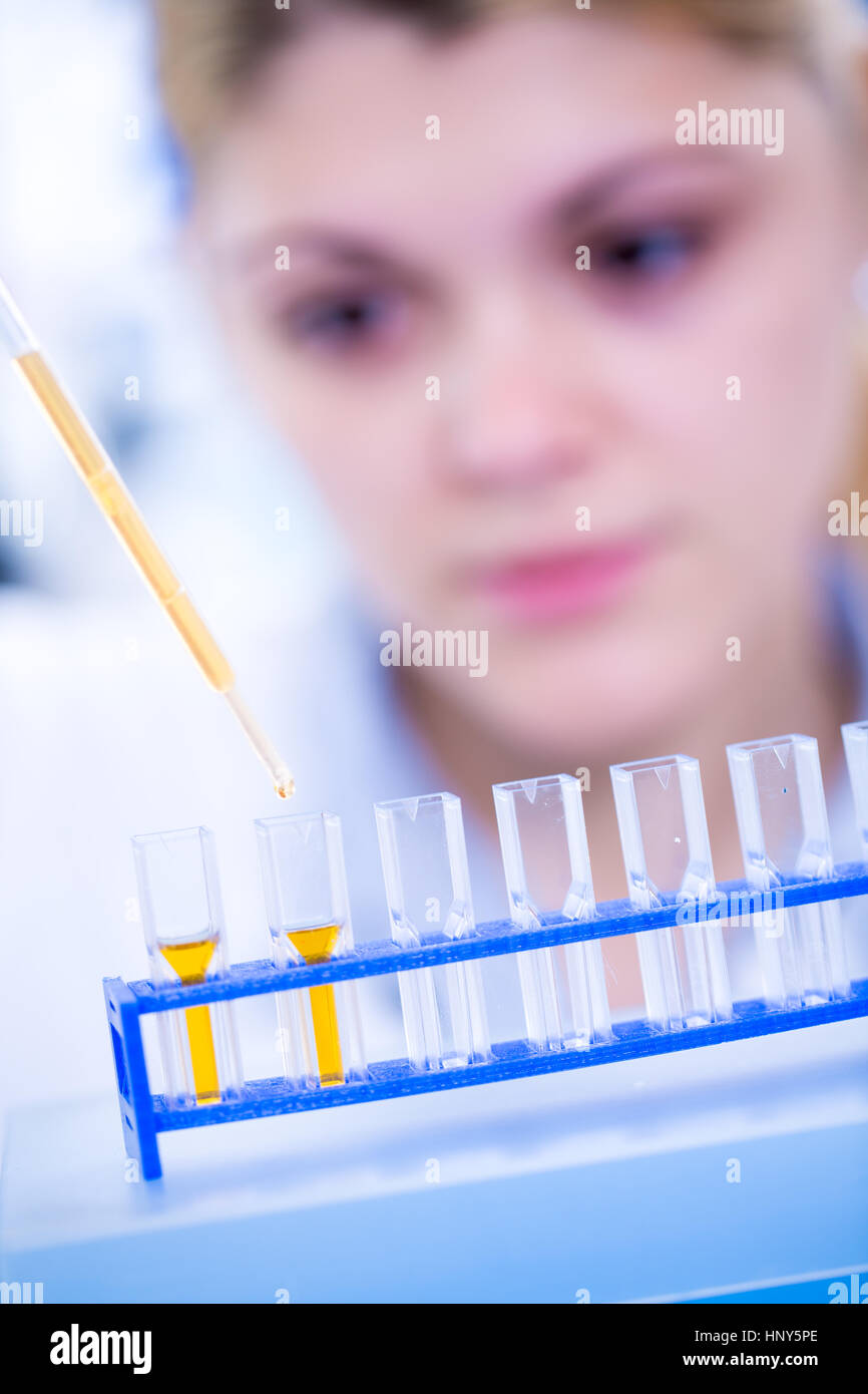 Scientist pipetting sample into test tube during experiment lab hi-res ...