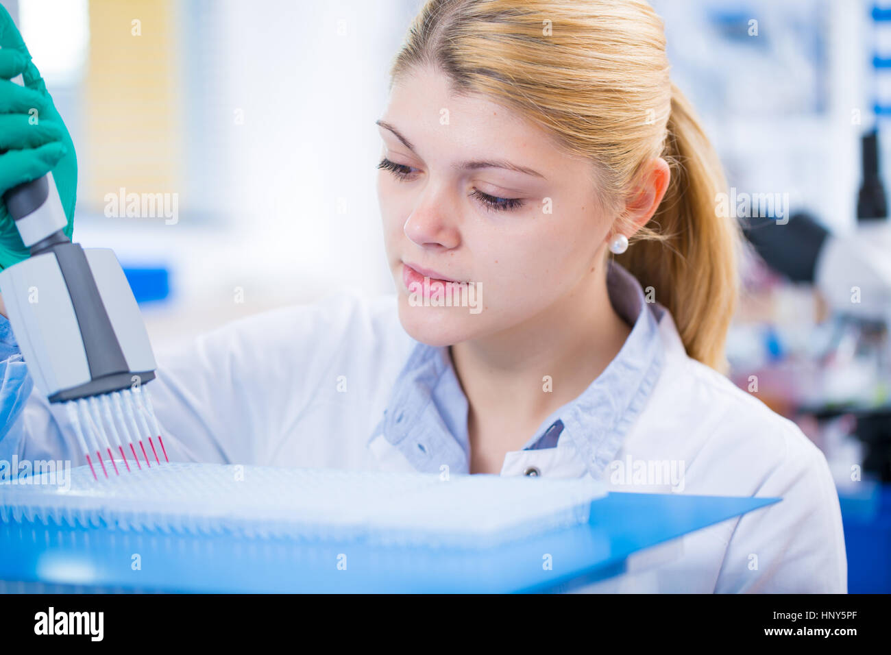 A young chemist holding test tube with liquid during chemical ...