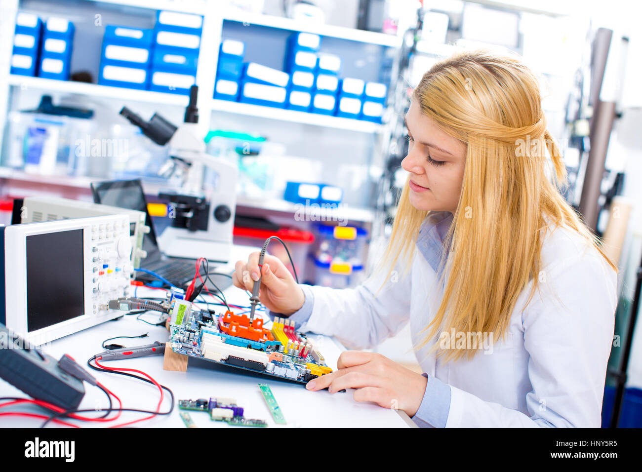 Engineer working with circuits. A woman engineer solders circuits ...