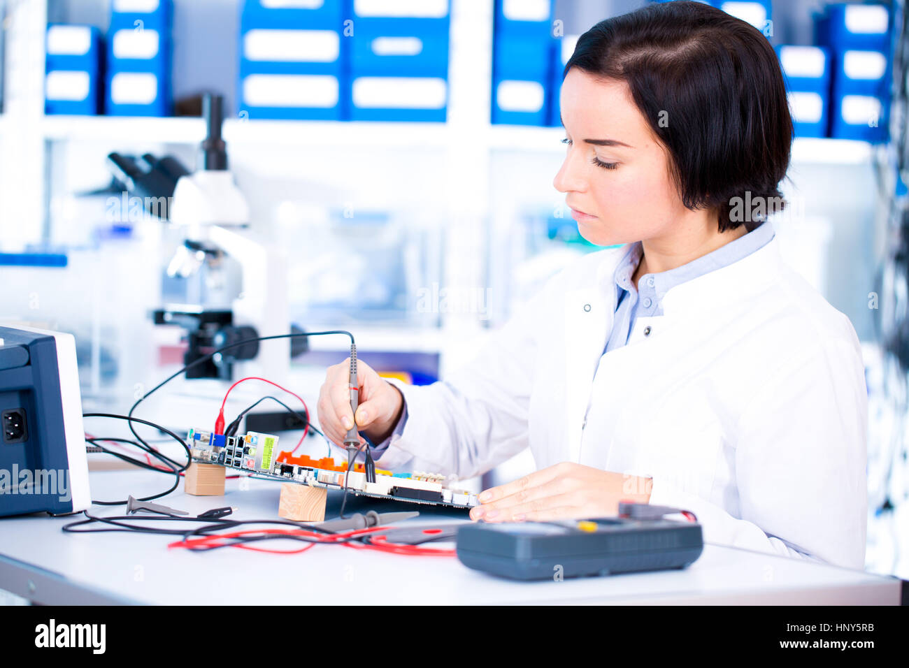 Engineer working with circuits. A woman engineer solders circuits ...