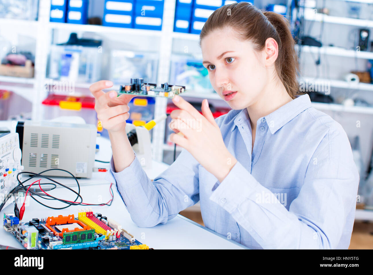 Engineer working with circuits. A woman engineer solders circuits ...