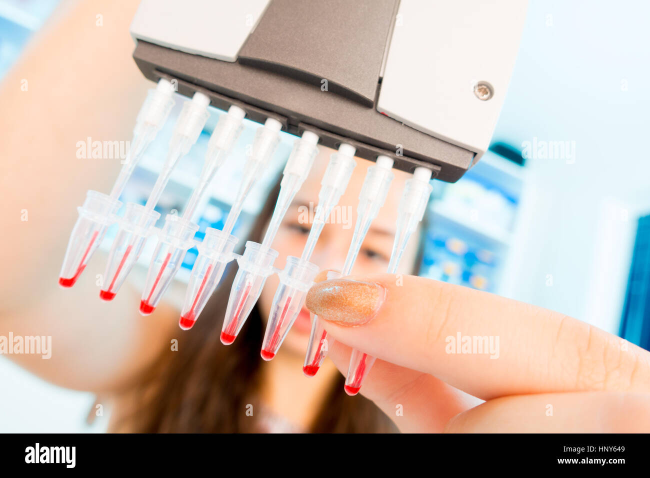 Woman technician with multipipette in genetic laboratory PCR research ...