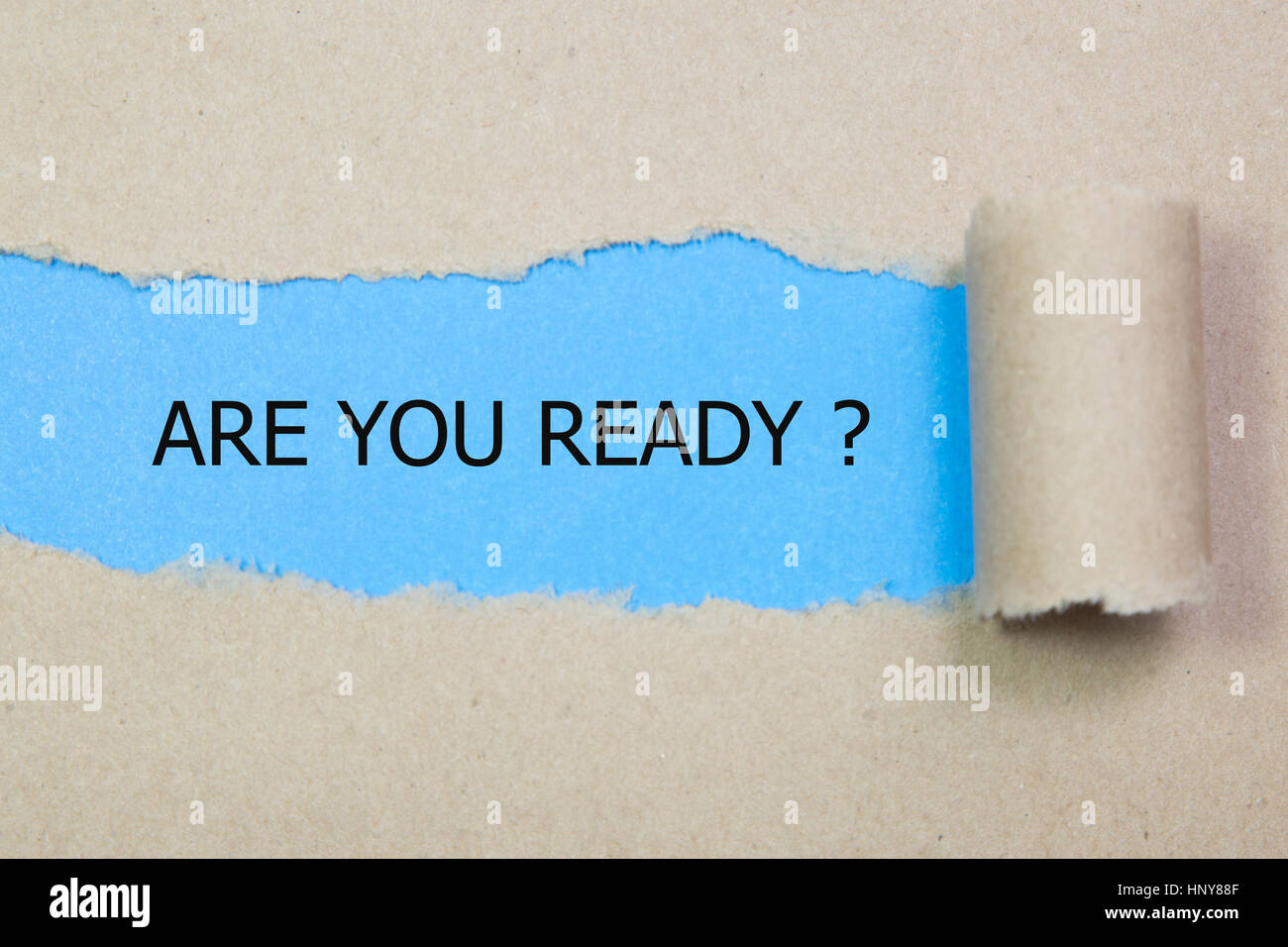 are you ready word written appearing behind torn paper Stock Photo - Alamy