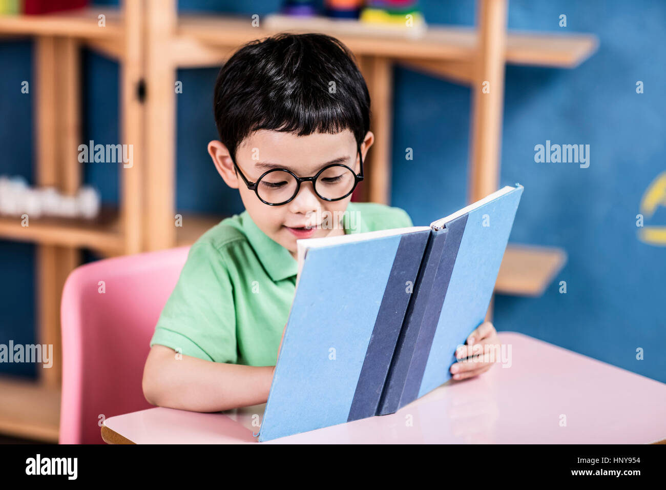 Kindergarten boy reading a book Stock Photo - Alamy