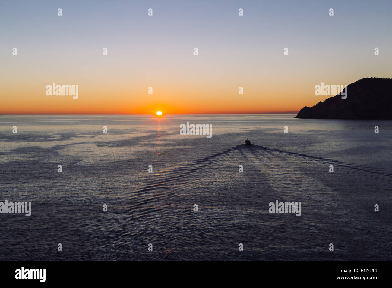 A boat heading into the sunset in Mediterranean Sea heading off the ...