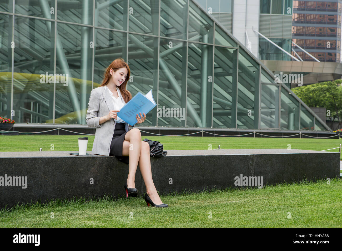 Businesswoman with file sitting Stock Photo - Alamy