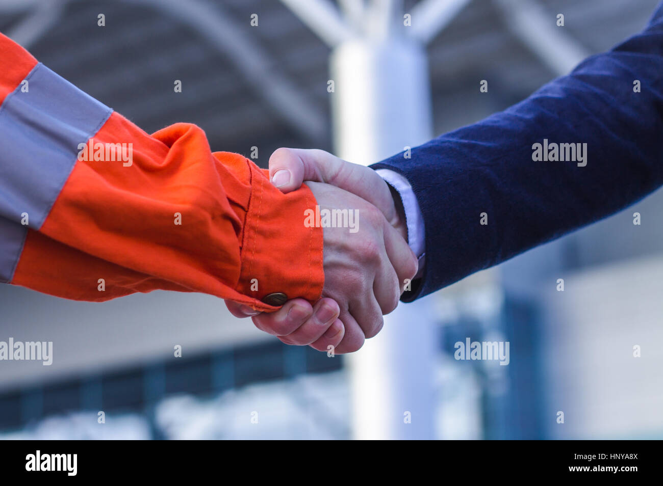 businessman handshaking with worker. Handshake of suit and boilersuit ...