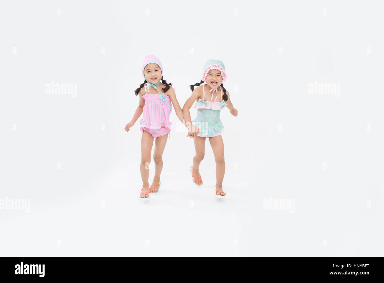 Smiling twin girls in swimsuits Stock Photo - Alamy