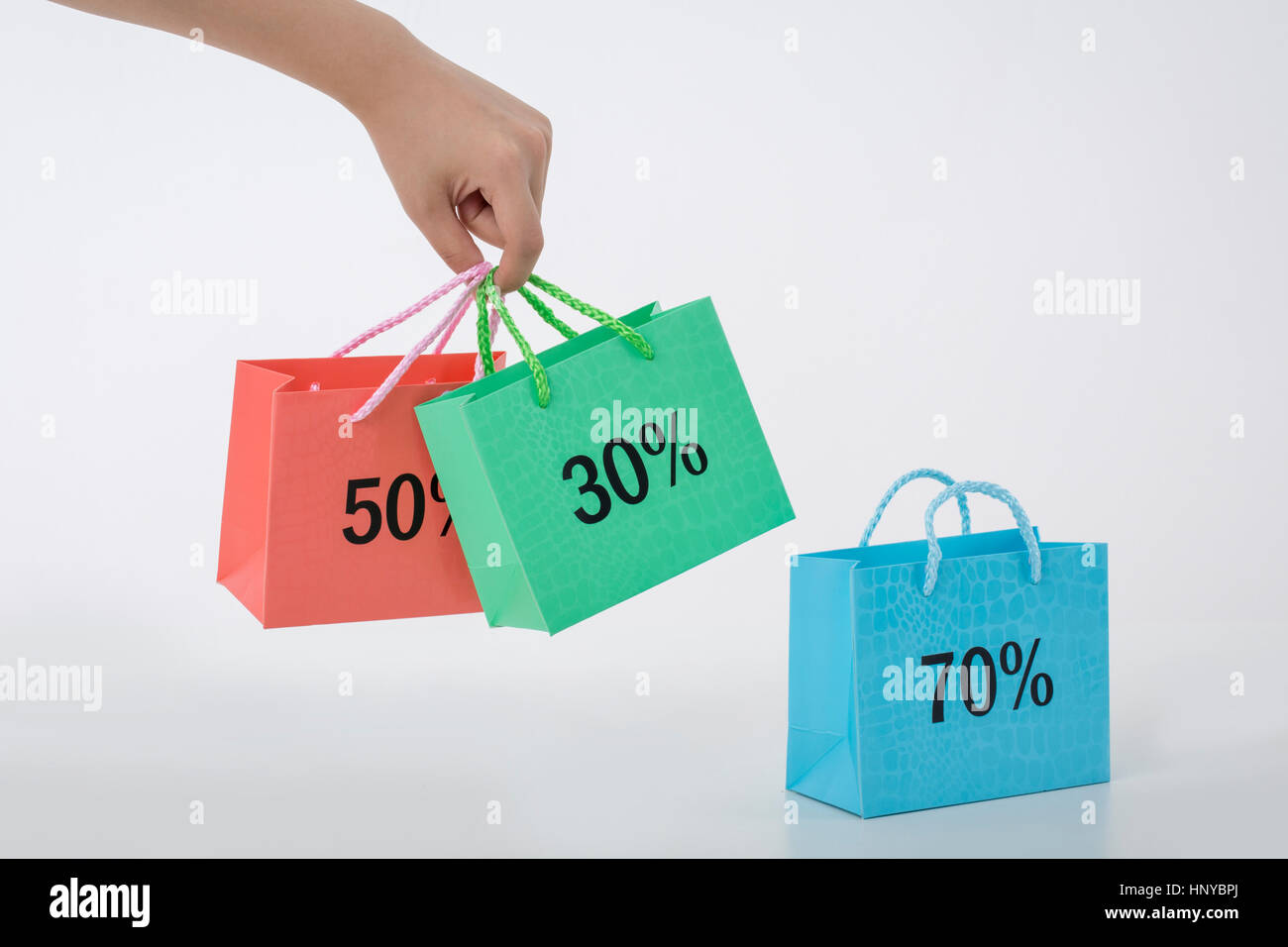 Hand holding shopping bags with Sale signs Stock Photo - Alamy