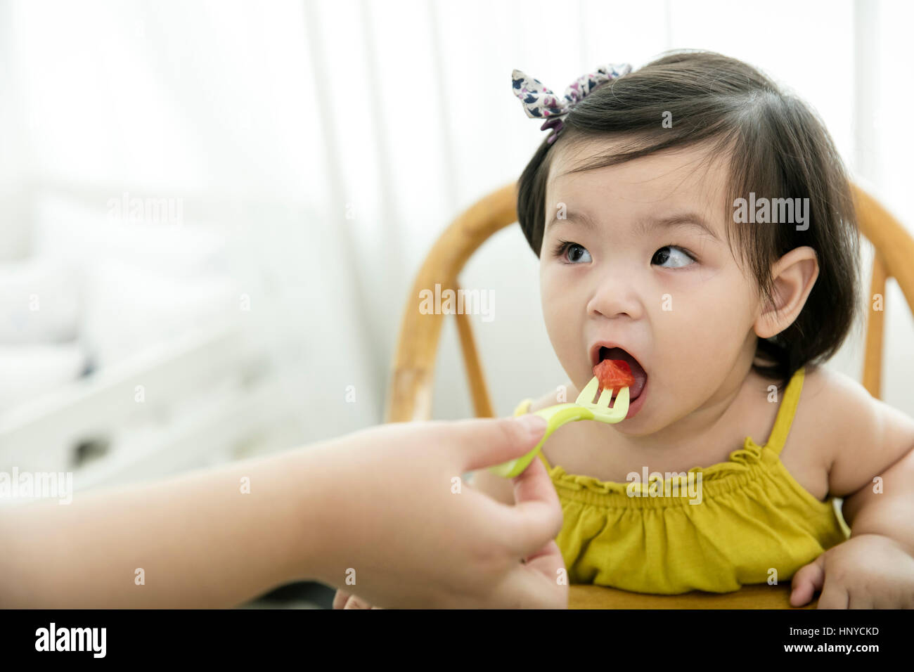 Portrait of baby girl eating Stock Photo - Alamy