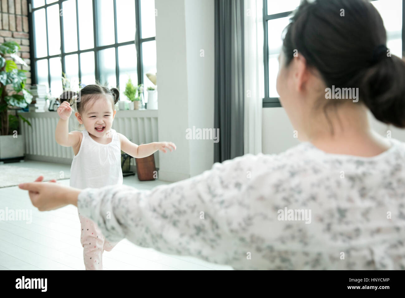Smiling baby girl running to her mother Stock Photo - Alamy