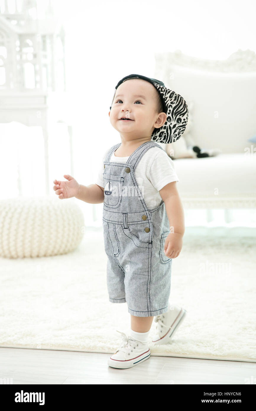 Smiling baby boy walking looking up Stock Photo - Alamy