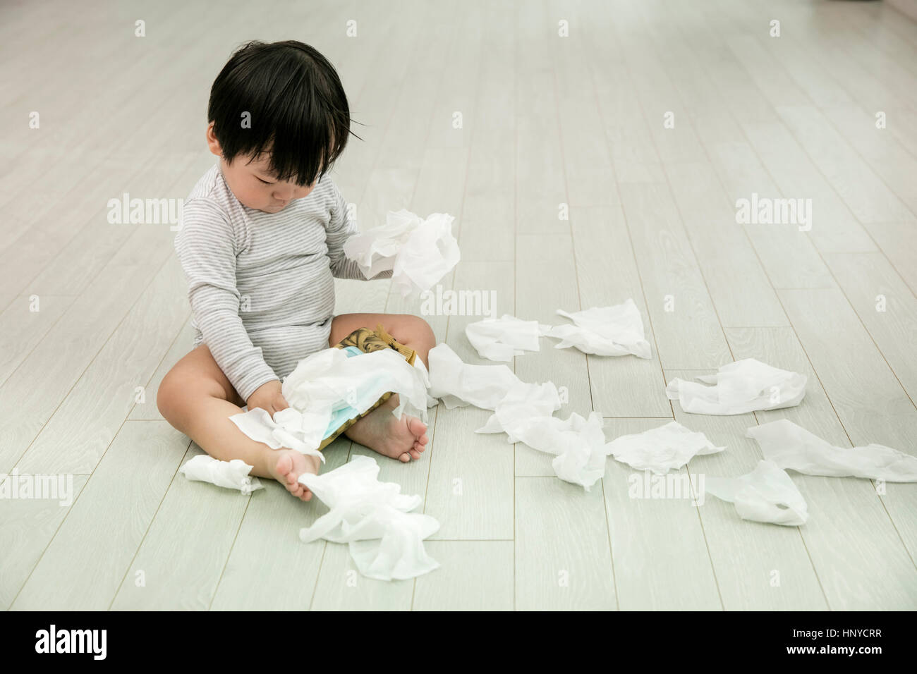 Baby boy making mess with tissue Stock Photo - Alamy