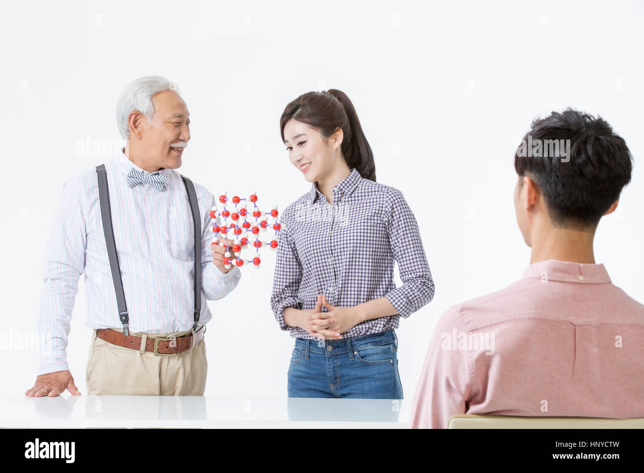 Smiling senior man teaching young people Stock Photo - Alamy