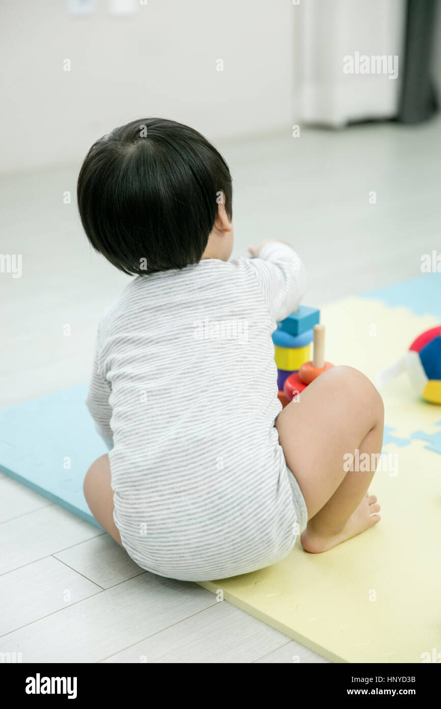 Back of baby boy playing with blocks Stock Photo - Alamy