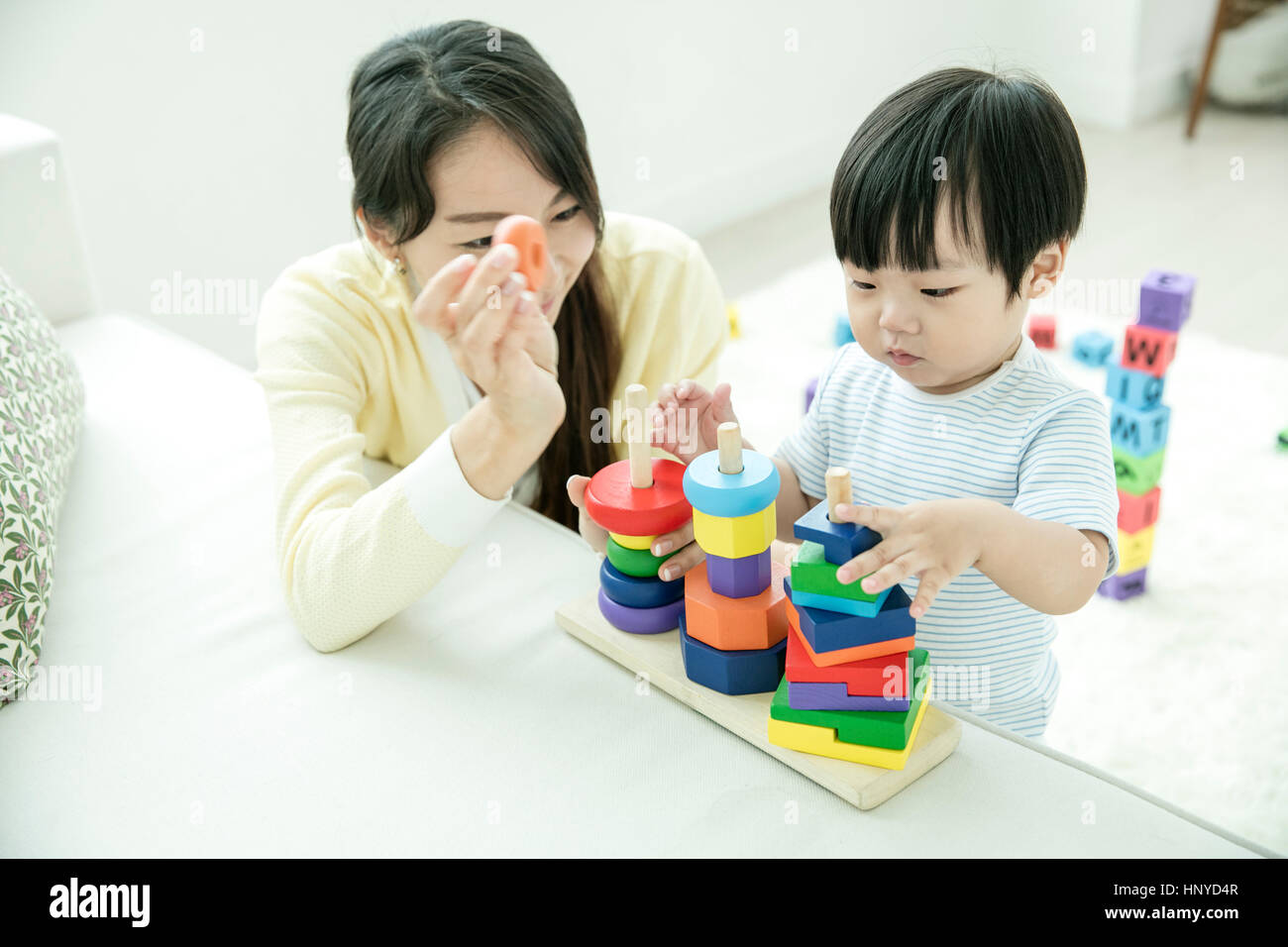 Loving mother and baby boy playing with toys Stock Photo - Alamy