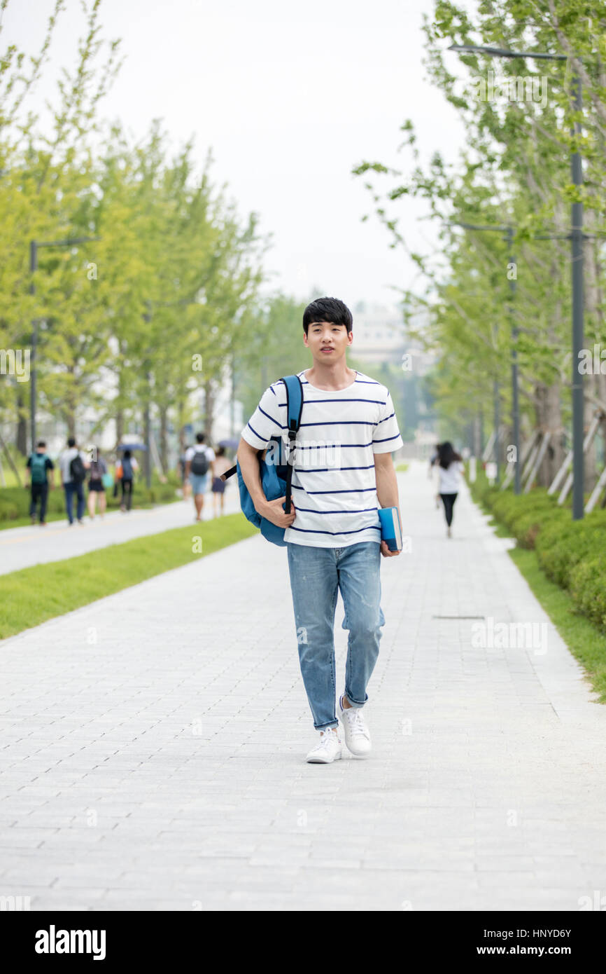 Male college student walking Stock Photo - Alamy