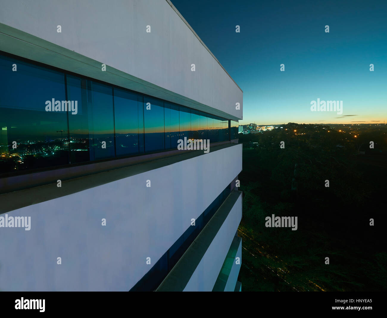 Office building at sunset light with reflecting of city in windows ...
