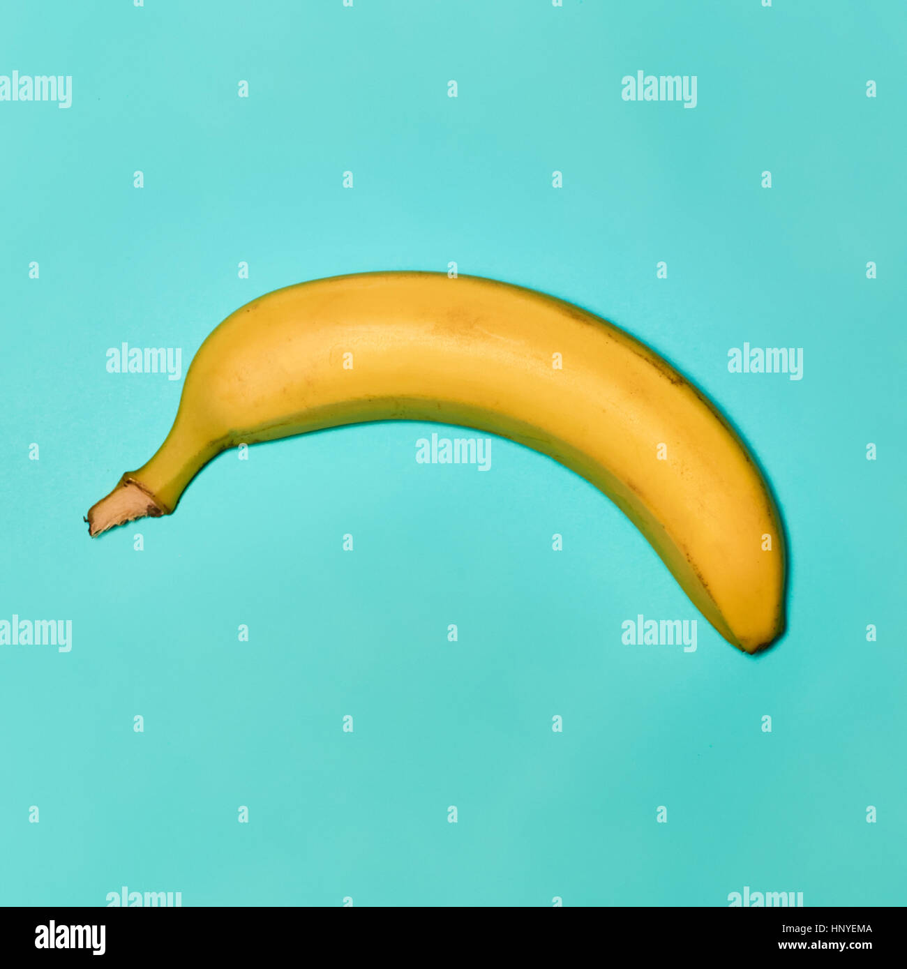Single banana against blue background Stock Photo - Alamy