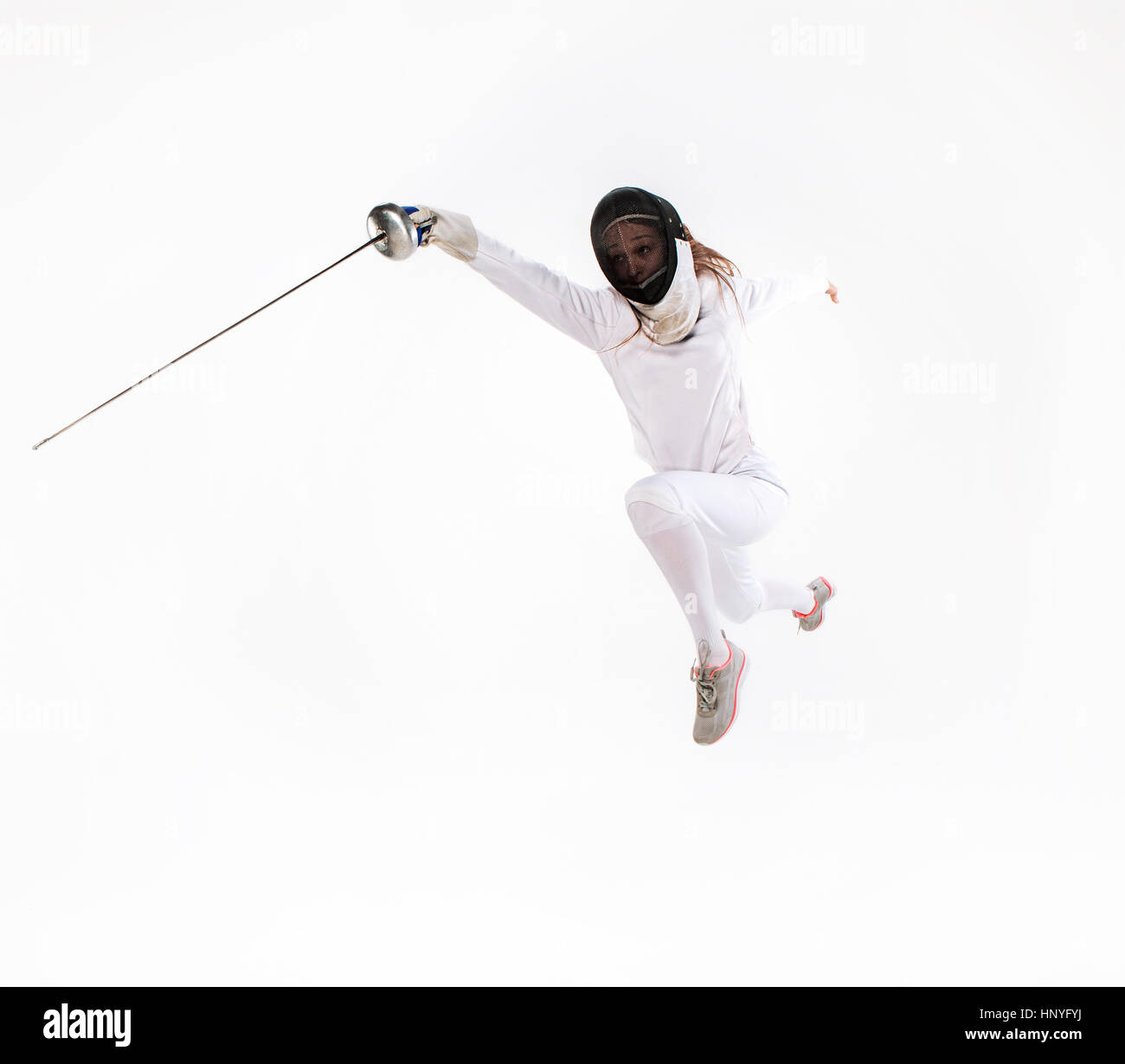 Man wearing fencing suit practicing with sword against gray Stock Photo ...