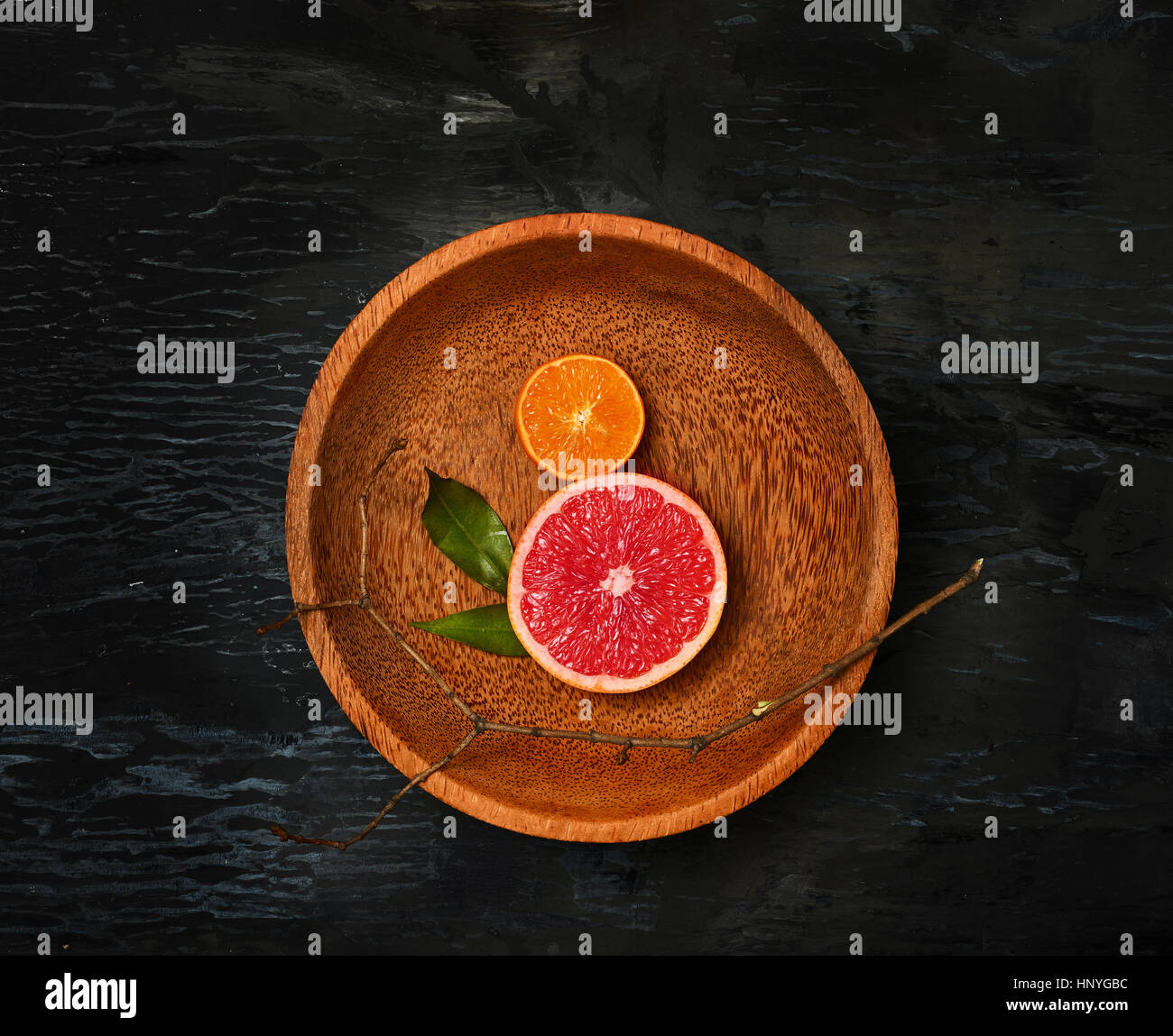 Grapefruit citrus fruit halves on wooden plate Stock Photo - Alamy