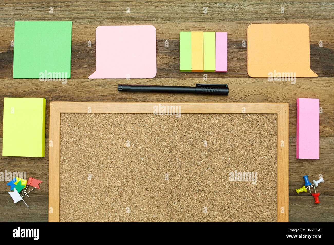 A colorful blank post it paper around a notice board with wooden ...