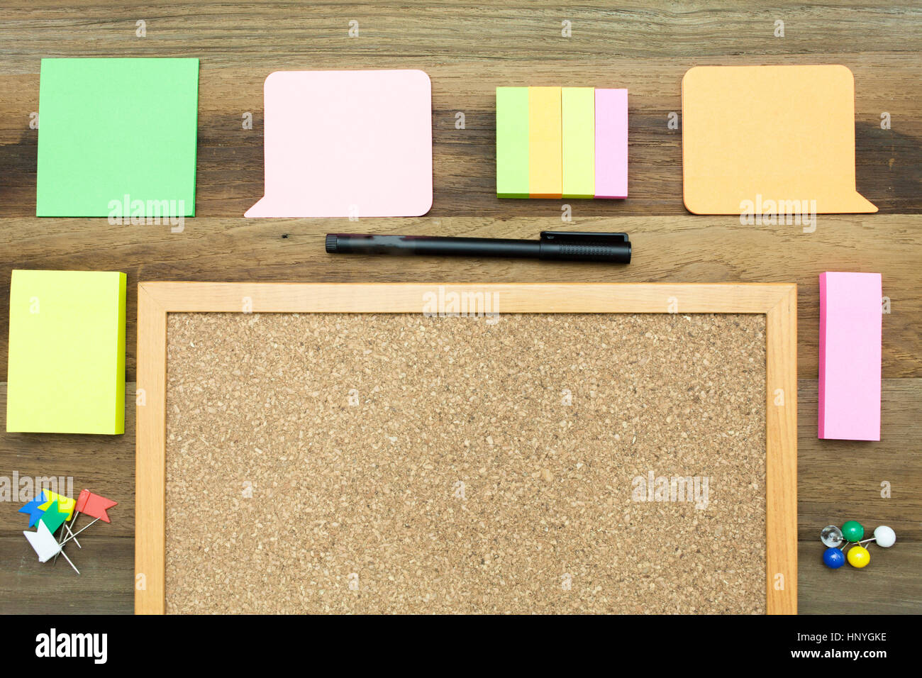 A colorful blank post it paper around a notice board with wooden ...