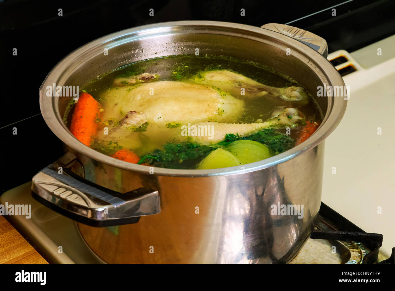 Big chicken is cooked in a saucepan on a gas stove Stock Photo - Alamy