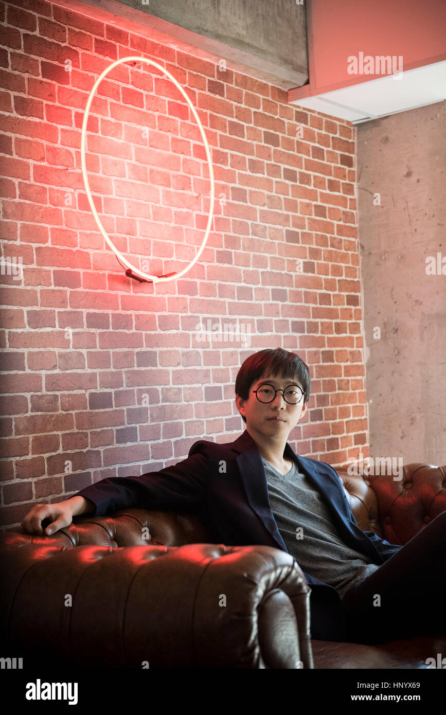 Man sitting on sofa, portrait Stock Photo - Alamy
