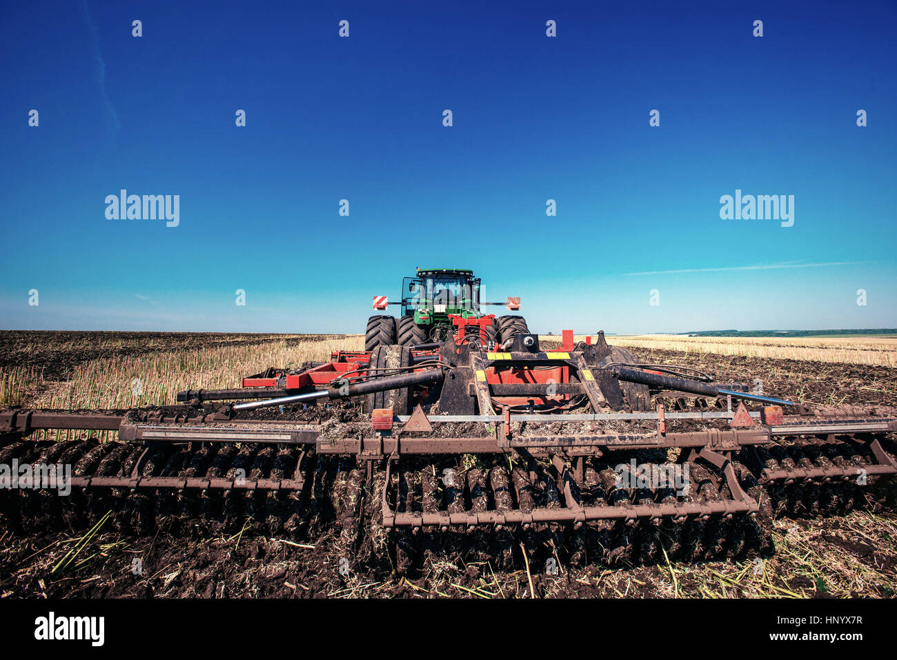 Tractor plowing farm field in preparation for spring planting Stock ...