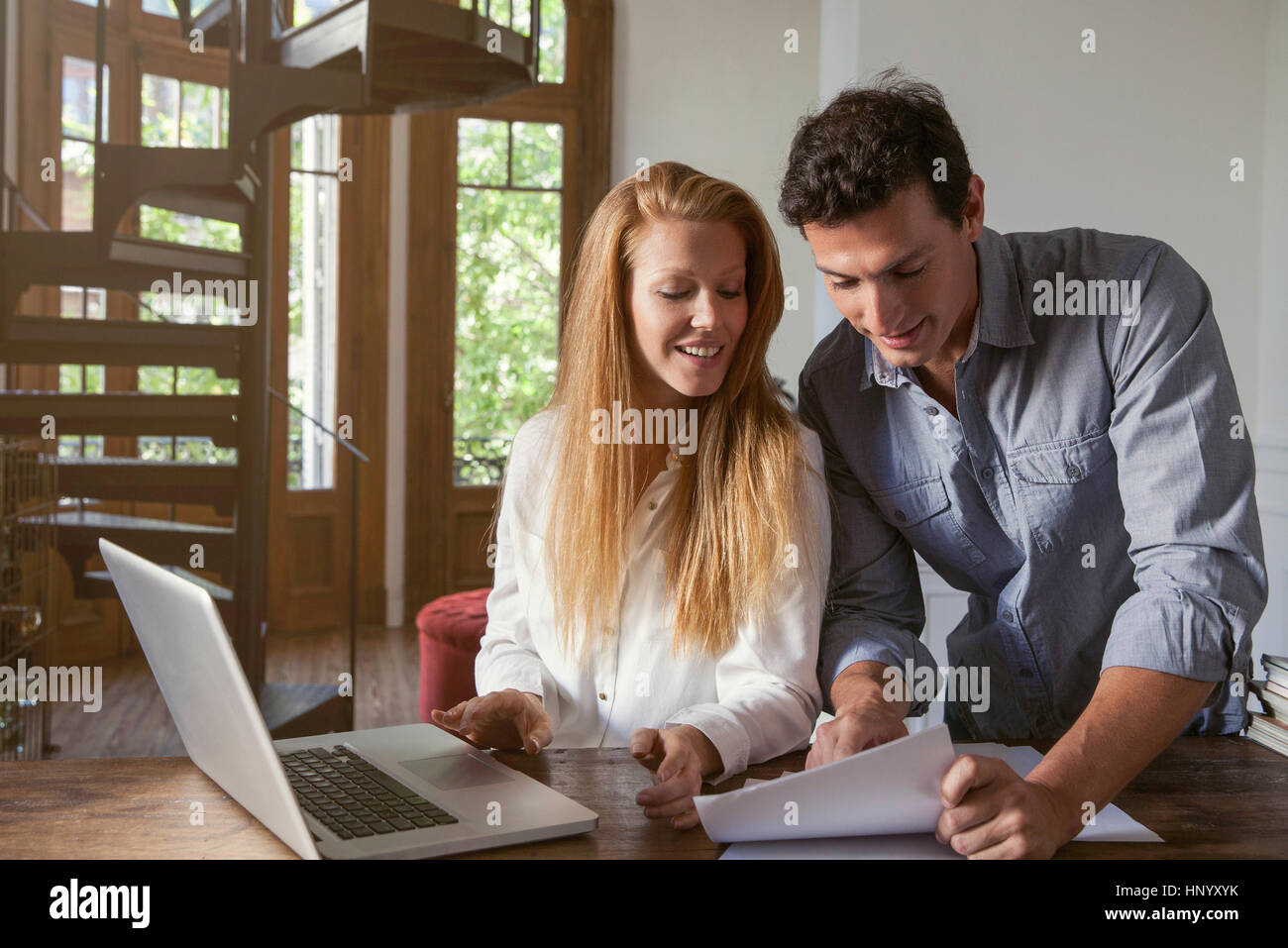 Couple looking at computers paperwork hi-res stock photography and ...