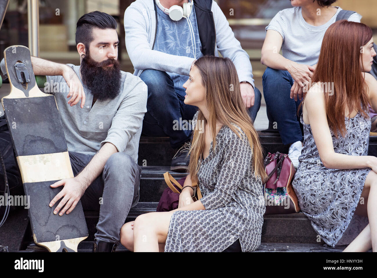 Friends chatting together on steps Stock Photo - Alamy